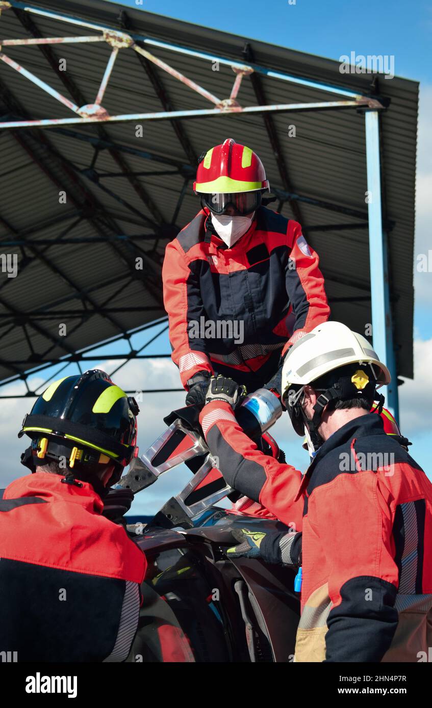 Group of firefighters wearing uniforms and helmets carry out a rescue ...