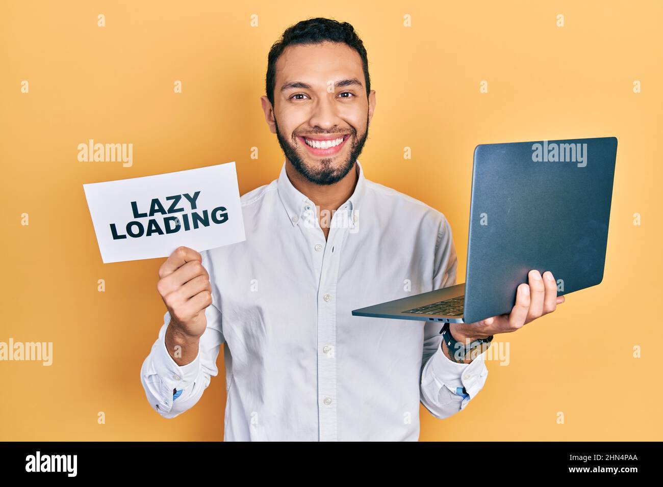 Hispanic man with beard working using computer laptop holding lazy ...