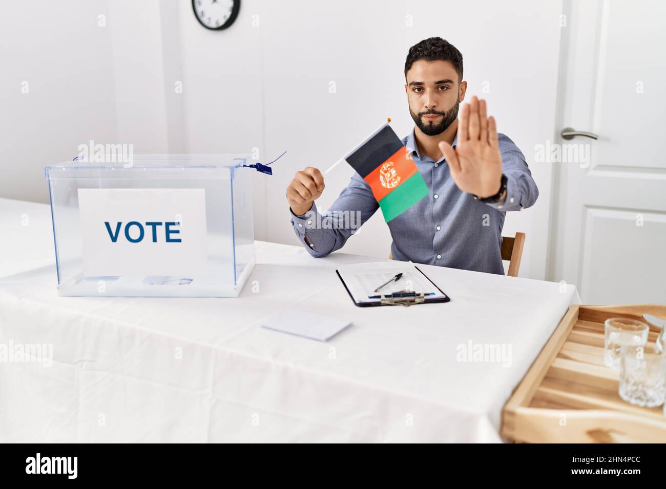 Young handsome man with beard at political campaign election holding ...
