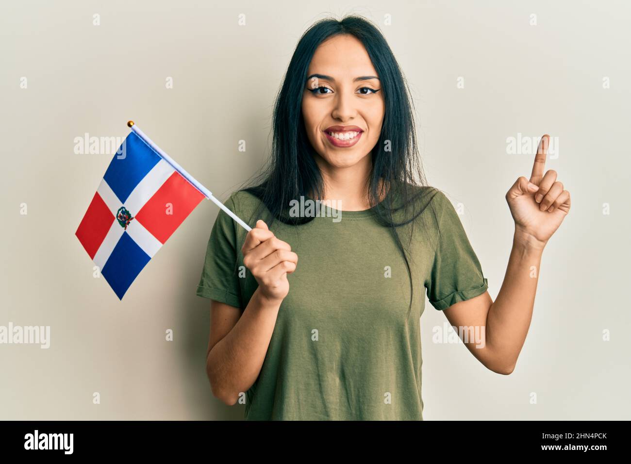 Young hispanic girl holding dominican republic flag smiling happy ...