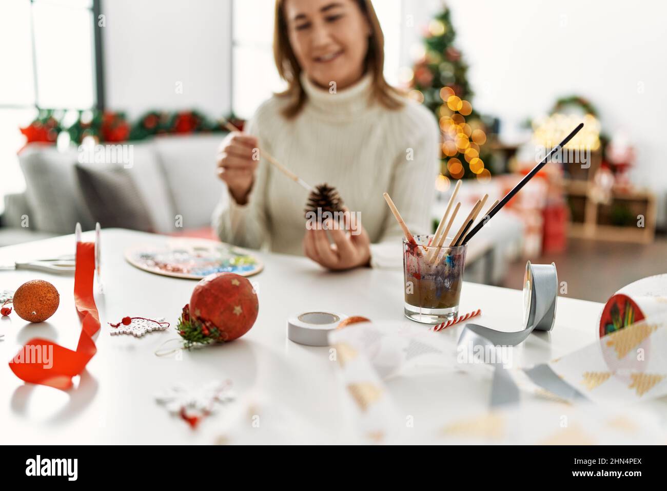 Middle age caucasian woman drawing pineapple to decor christmas tree at ...