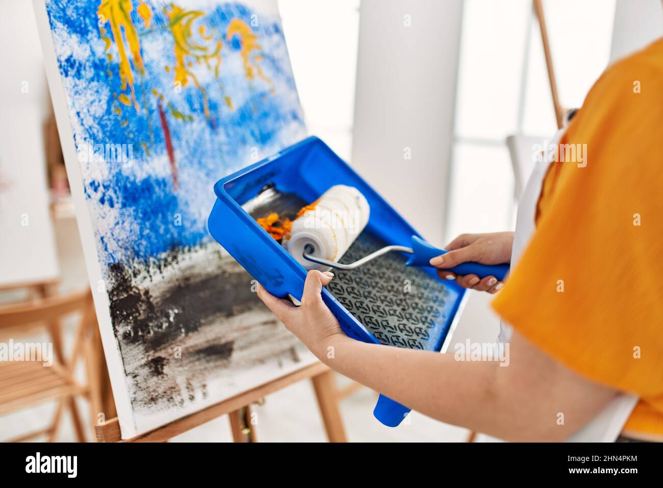 Woman paint student painting using roller at art studio Stock Photo - Alamy