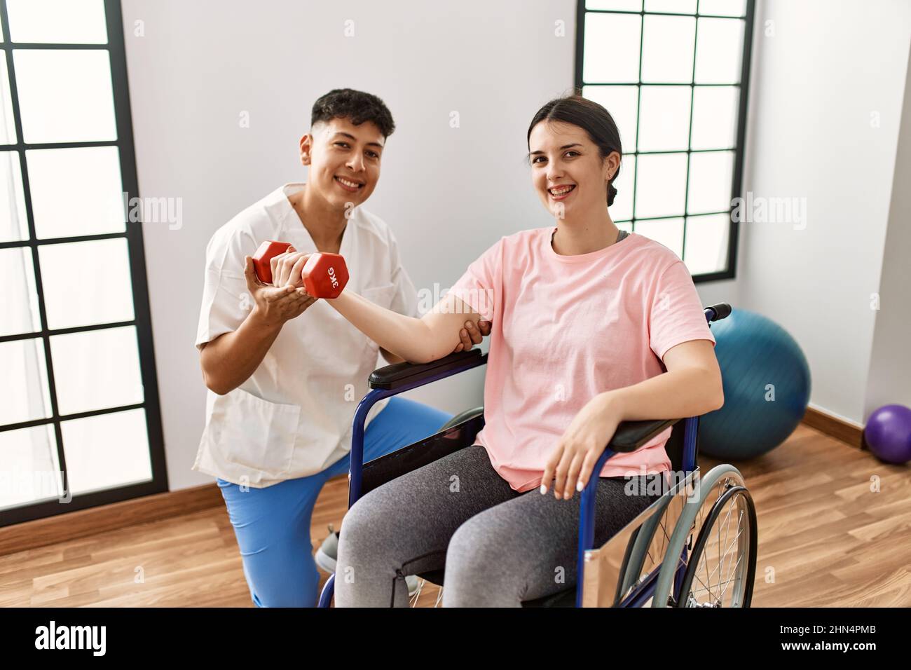 Young disabled woman sitting on wheelchair making mobility exercise ...