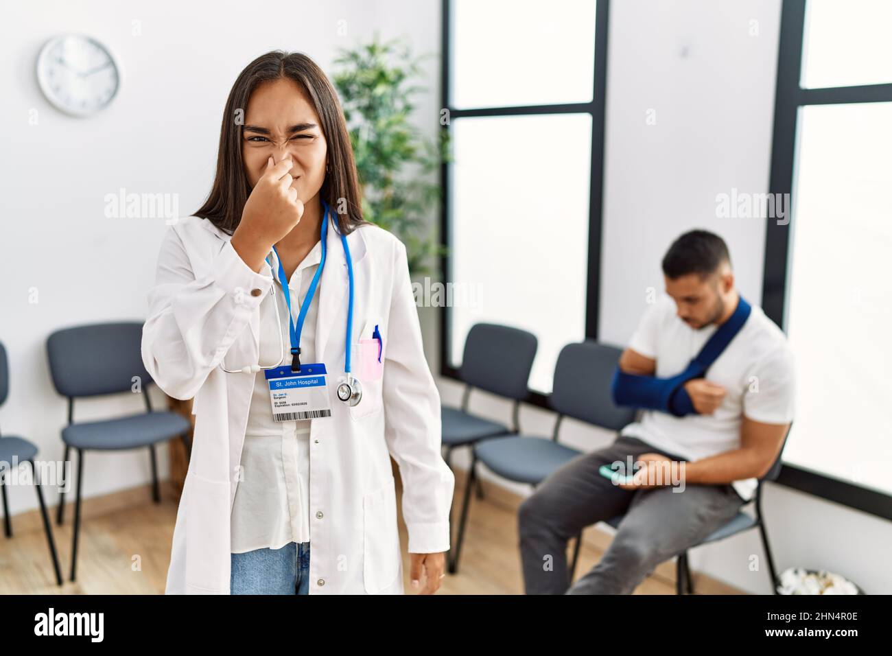 Young asian doctor woman at waiting room with a man with a broken arm ...