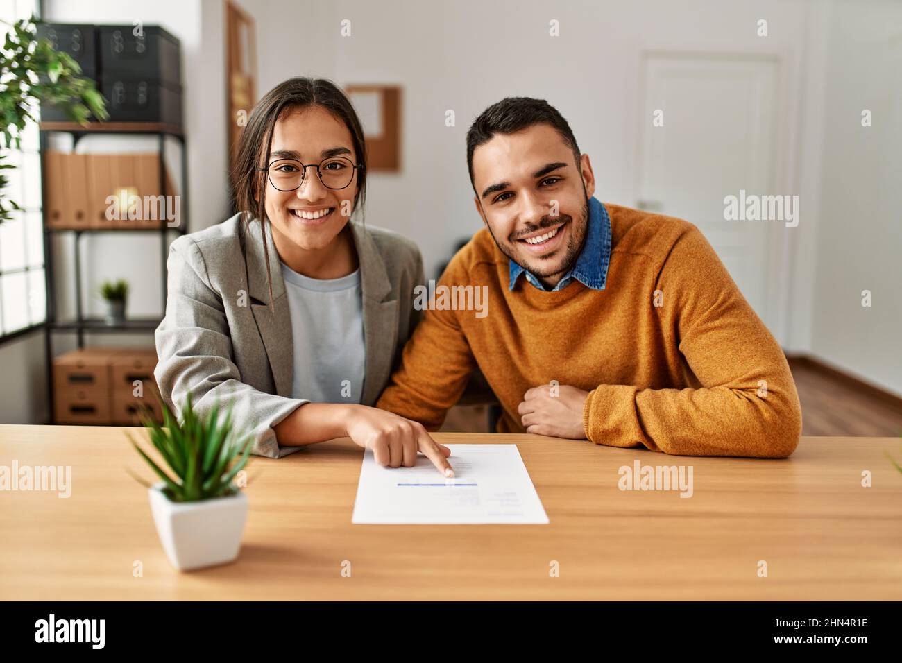 Couple smiling happy reading document at the office Stock Photo - Alamy