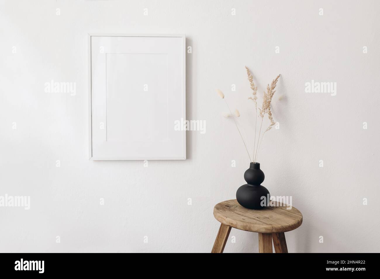 Portrait empty picture frame mockup in sunlight. Dry festuca, bunny ...