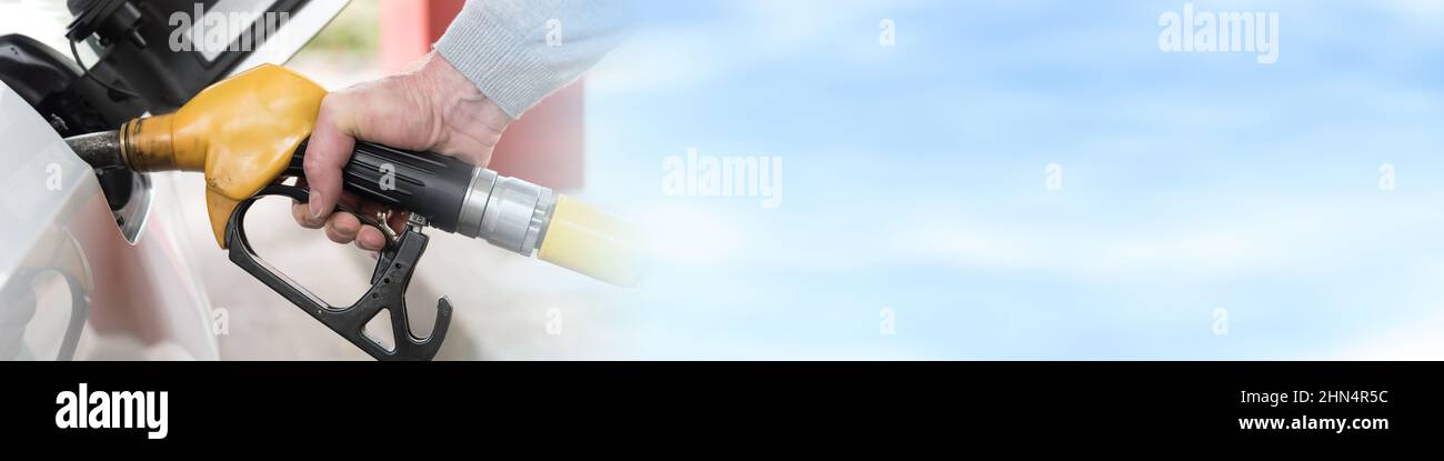 Hand holding yellow fuel pump nozzle and refilling car Stock Photo - Alamy