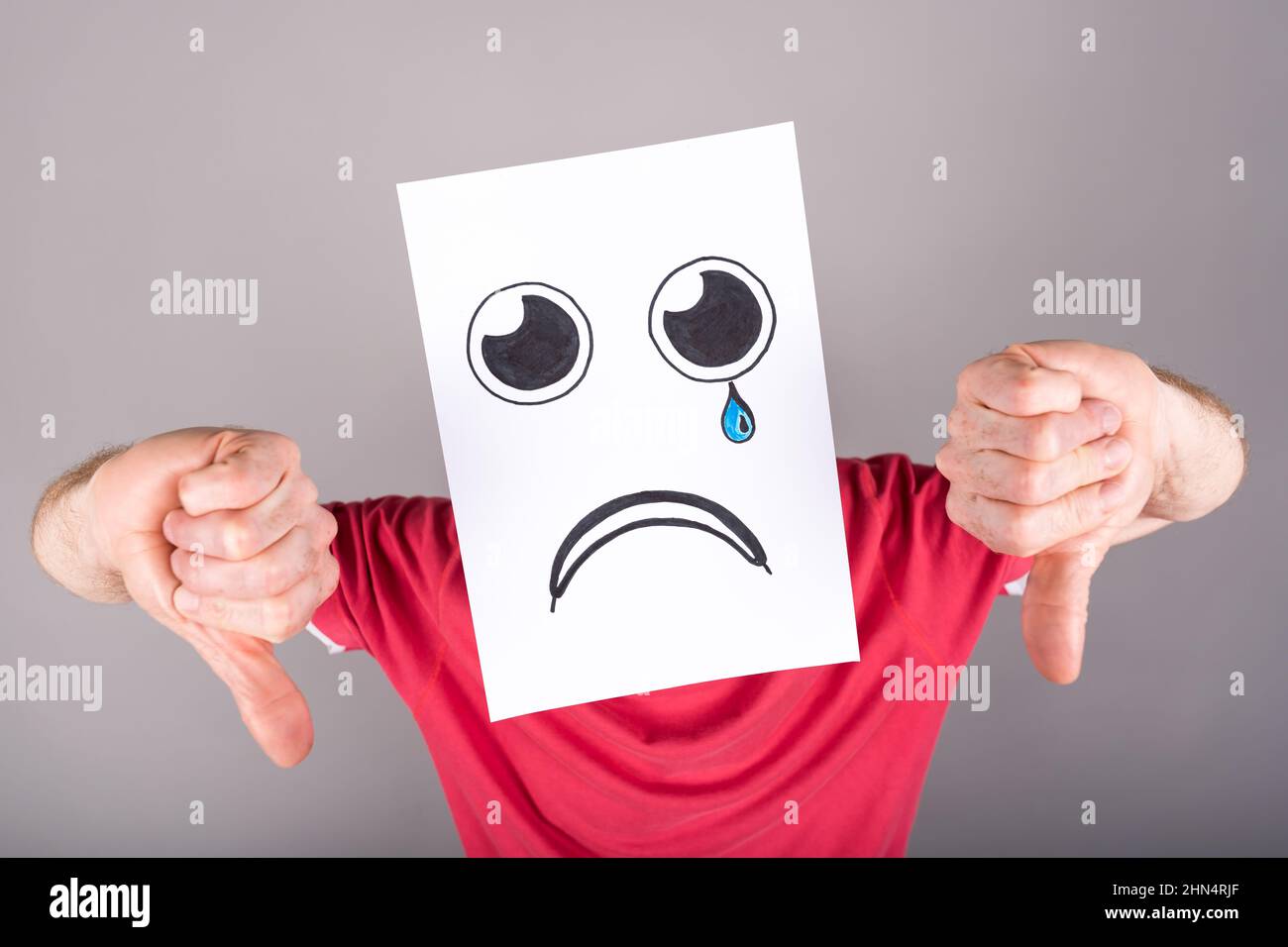 Man behind a paper with a sadness expression Stock Photo - Alamy