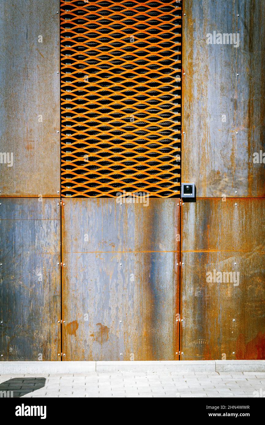 Modern architecture rusty metal wall and a sidewalk Stock Photo - Alamy