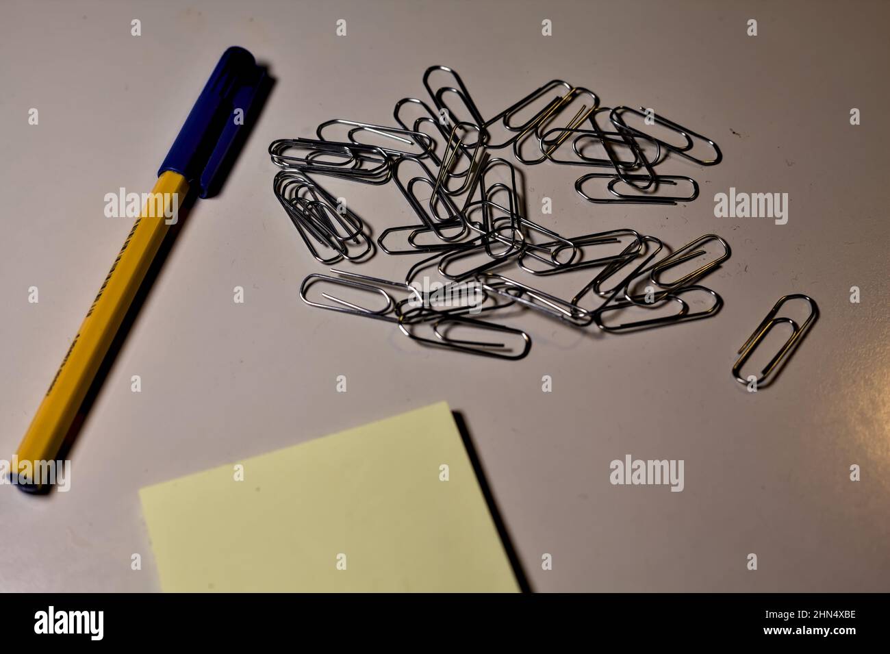 Pen with a notepaper block and clips on a desk Stock Photo - Alamy