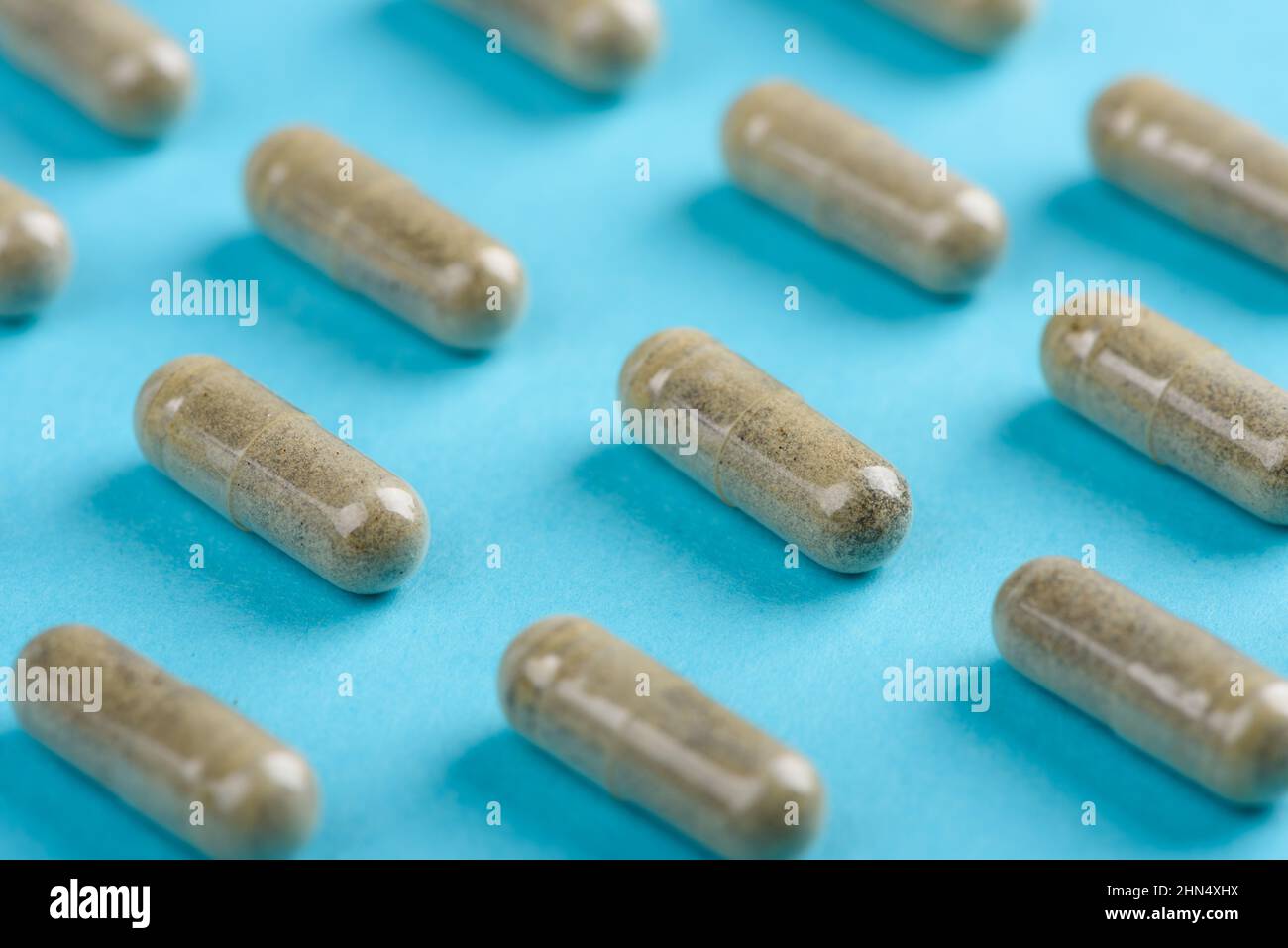 Transparent capsule pill pattern on blue background Stock Photo - Alamy