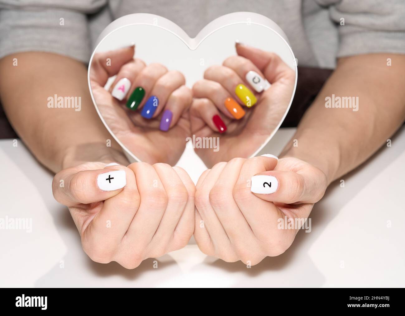 Woman Hands With Lgbt Rainbow Flag And Rose Triangle Manicure In The