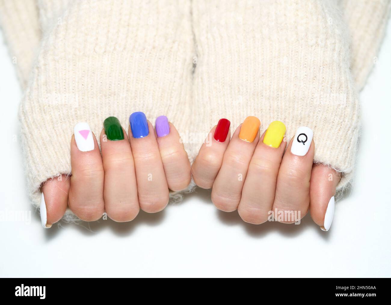 Hands with LGBT rainbow flag and rose triangle manicure. Symbol of ...