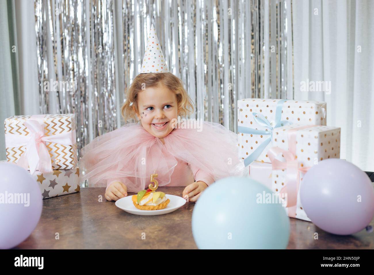 Cute little girl with short curly hair and stars on face in pink poofy ...
