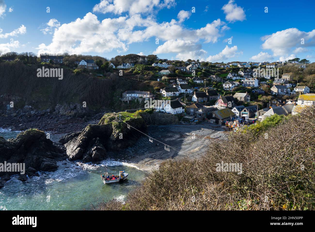 View of Cadgwith Cove, Cornwall, showing the houses and a fishing boat ...