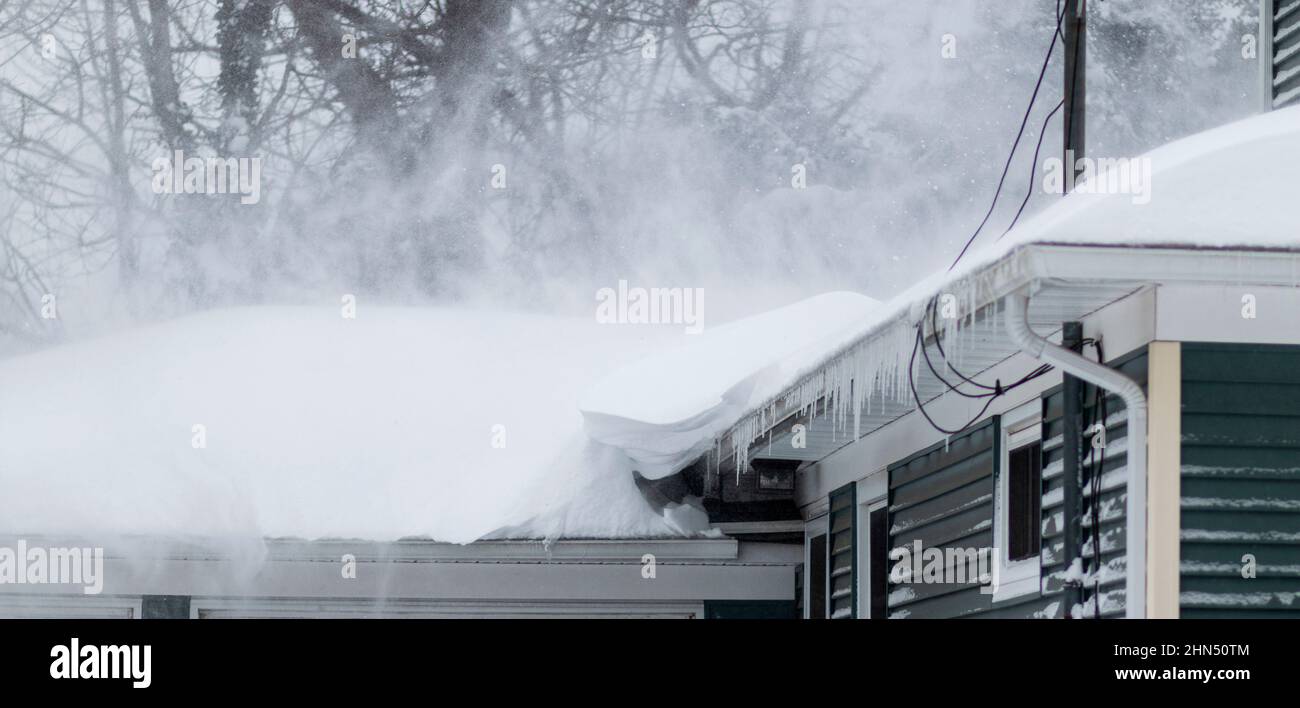 A residential house has snow blowing off its roof during a blizzard on ...