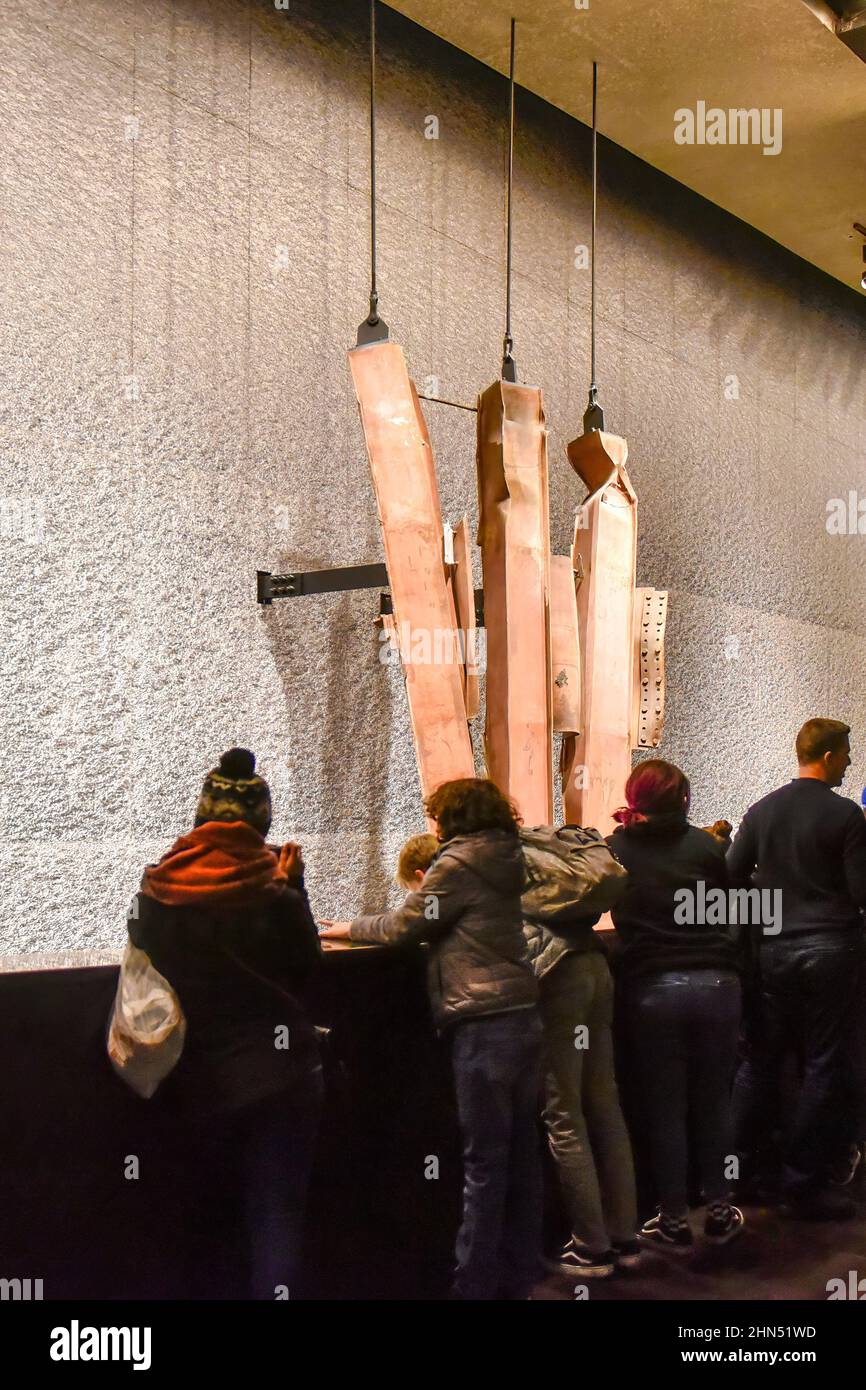 Tourists watching pieces of twisted metal columns which are ruins or ...