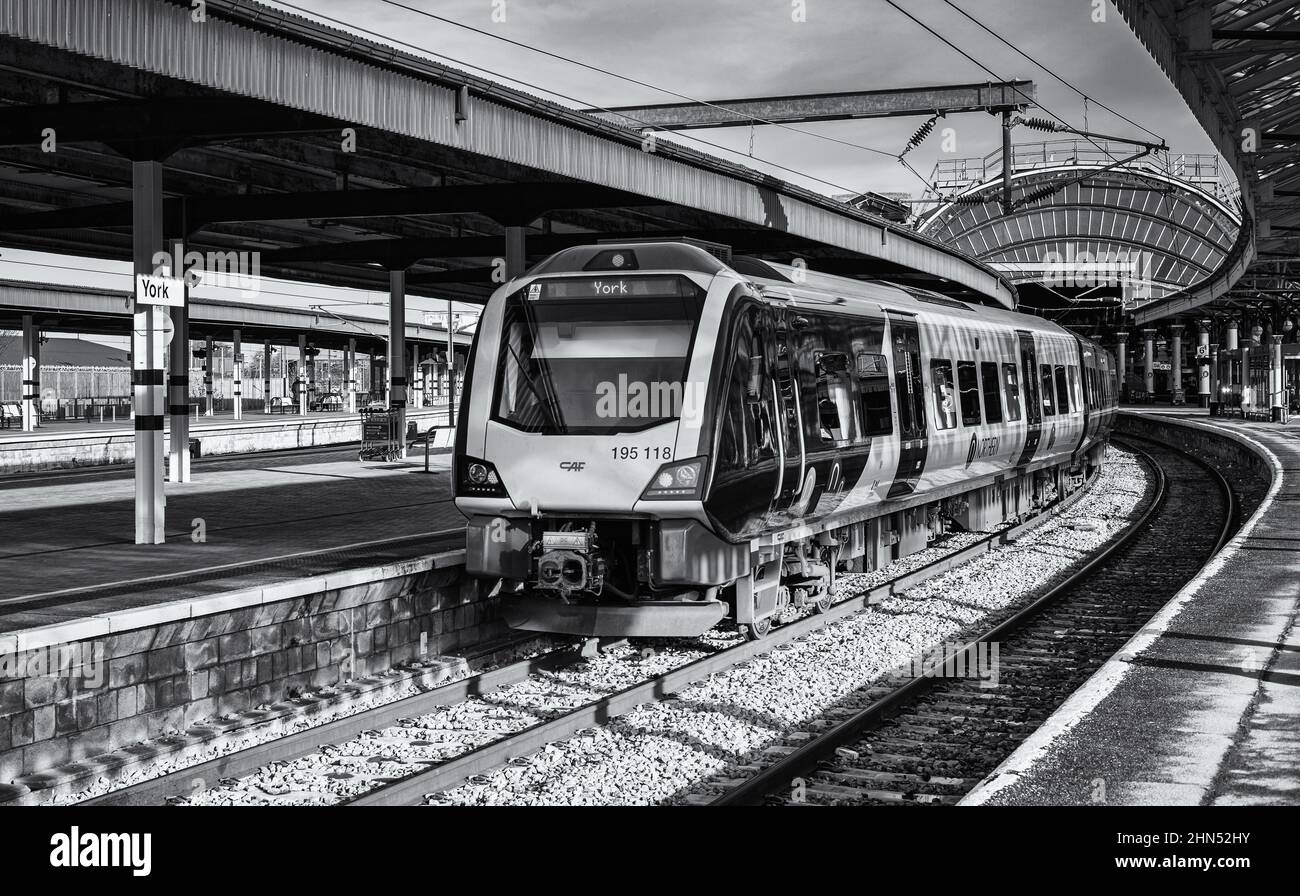Typical view of a railway station platform with a train alongside. A ...
