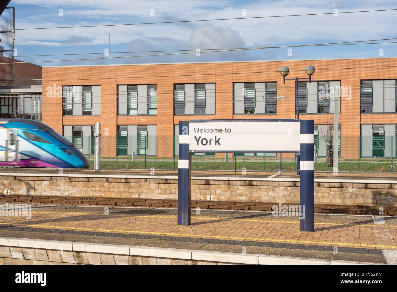 A place name welcome sign on a railway station platform. A modern ...