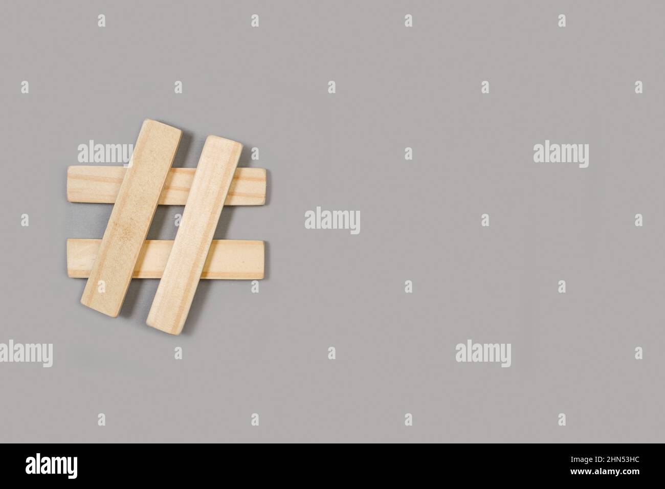Hashtag symbol made with wooden bars on a gray background with copy ...