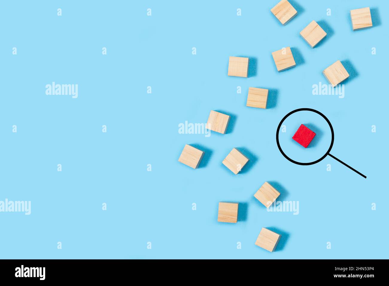 Square wooden blocks and one red on a light blue background with copy ...