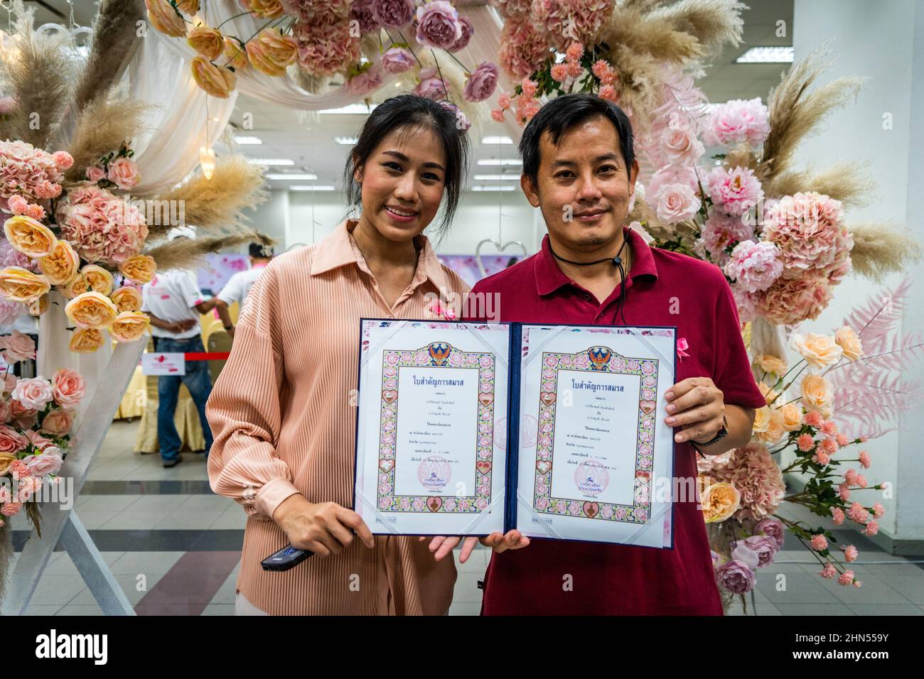 A couple poses for a photo with their marriage license at a mass ...
