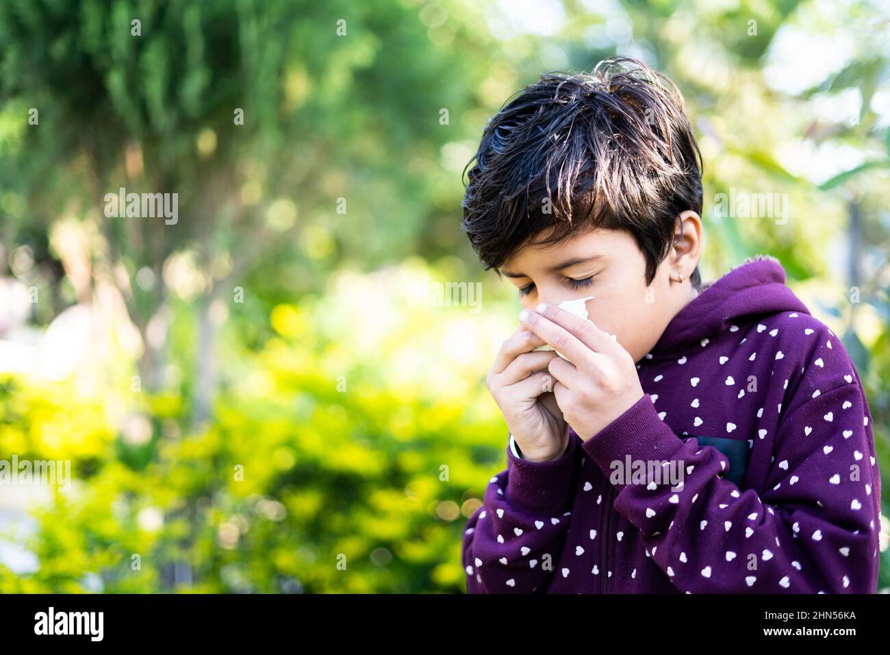 Young sick kid sneezing at park during winter - concept of seasonal ...