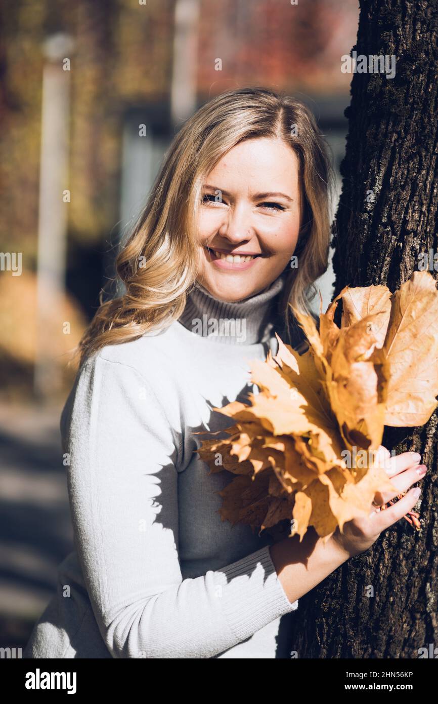 Good Looking Smiling Woman With Wavy Fair Hair In Roll Neck Sweater