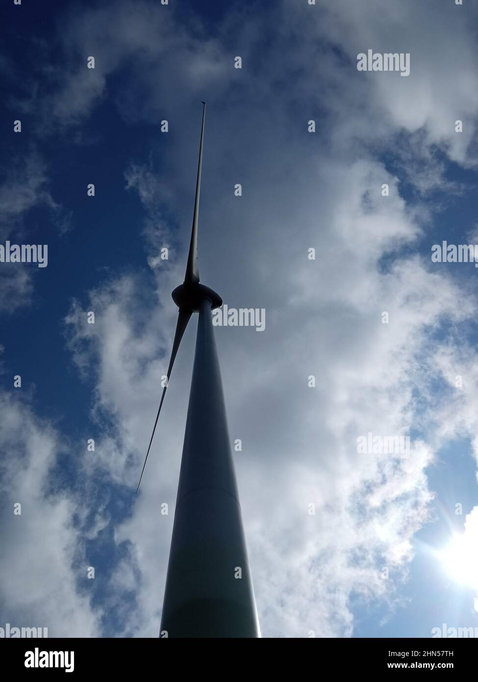 High wind turbine under blue sky with a lot of clouds. The way for a ...