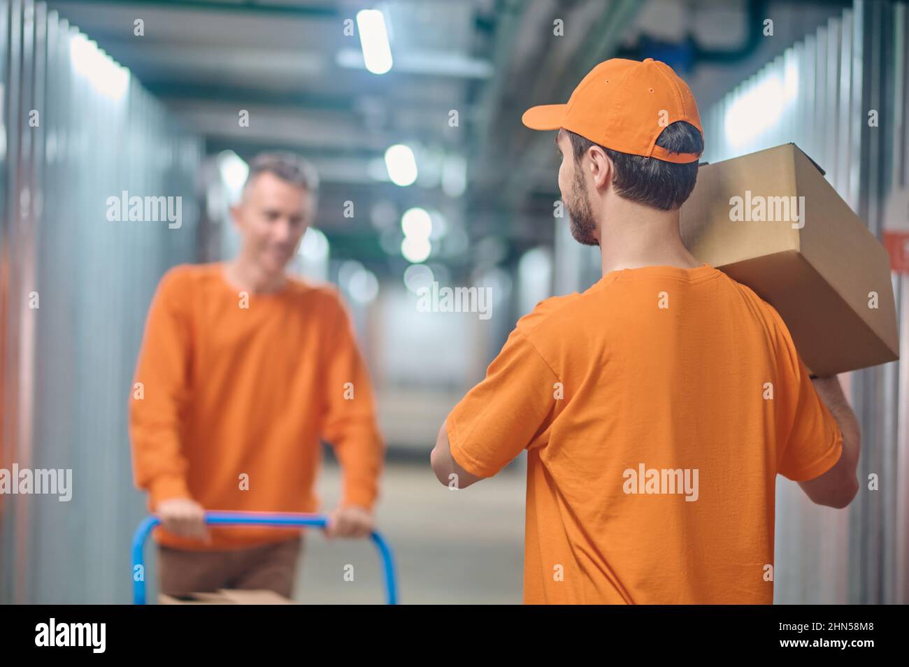 Two warehouse workers in the storage area Stock Photo - Alamy