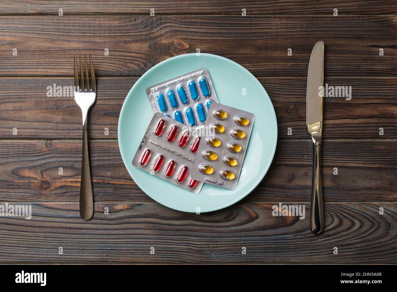 Many different weight loss pills and supplements as food on round plate ...