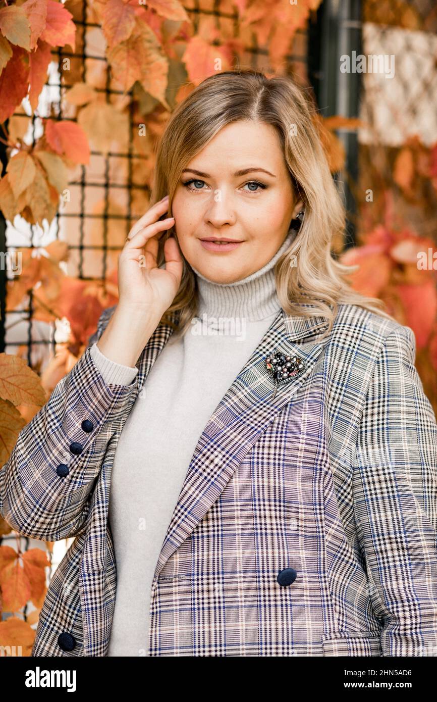Good Looking Smiling Middle Aged Woman In Checkered Jacket And Grey