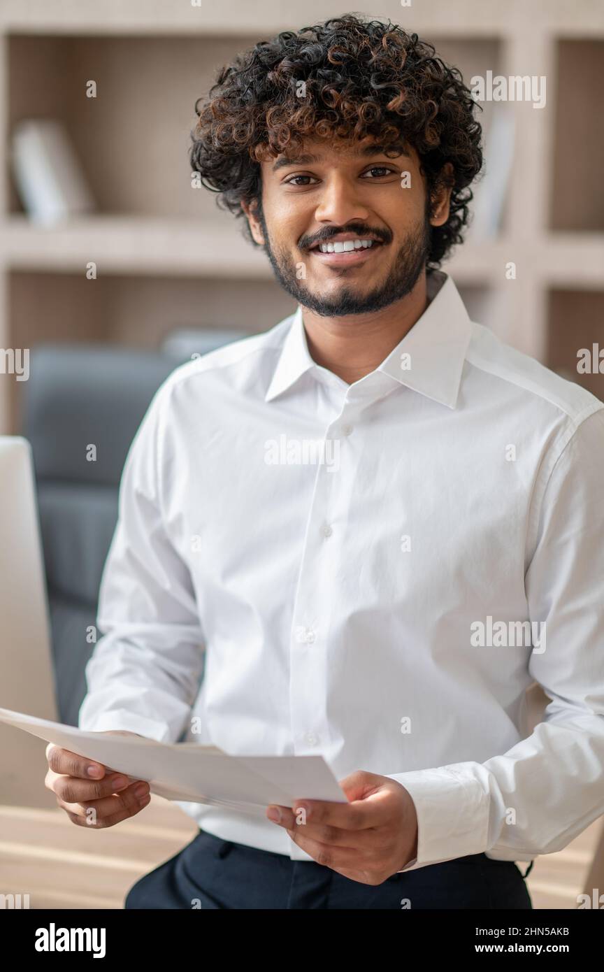 Young indian man in a white shirt in the office Stock Photo - Alamy