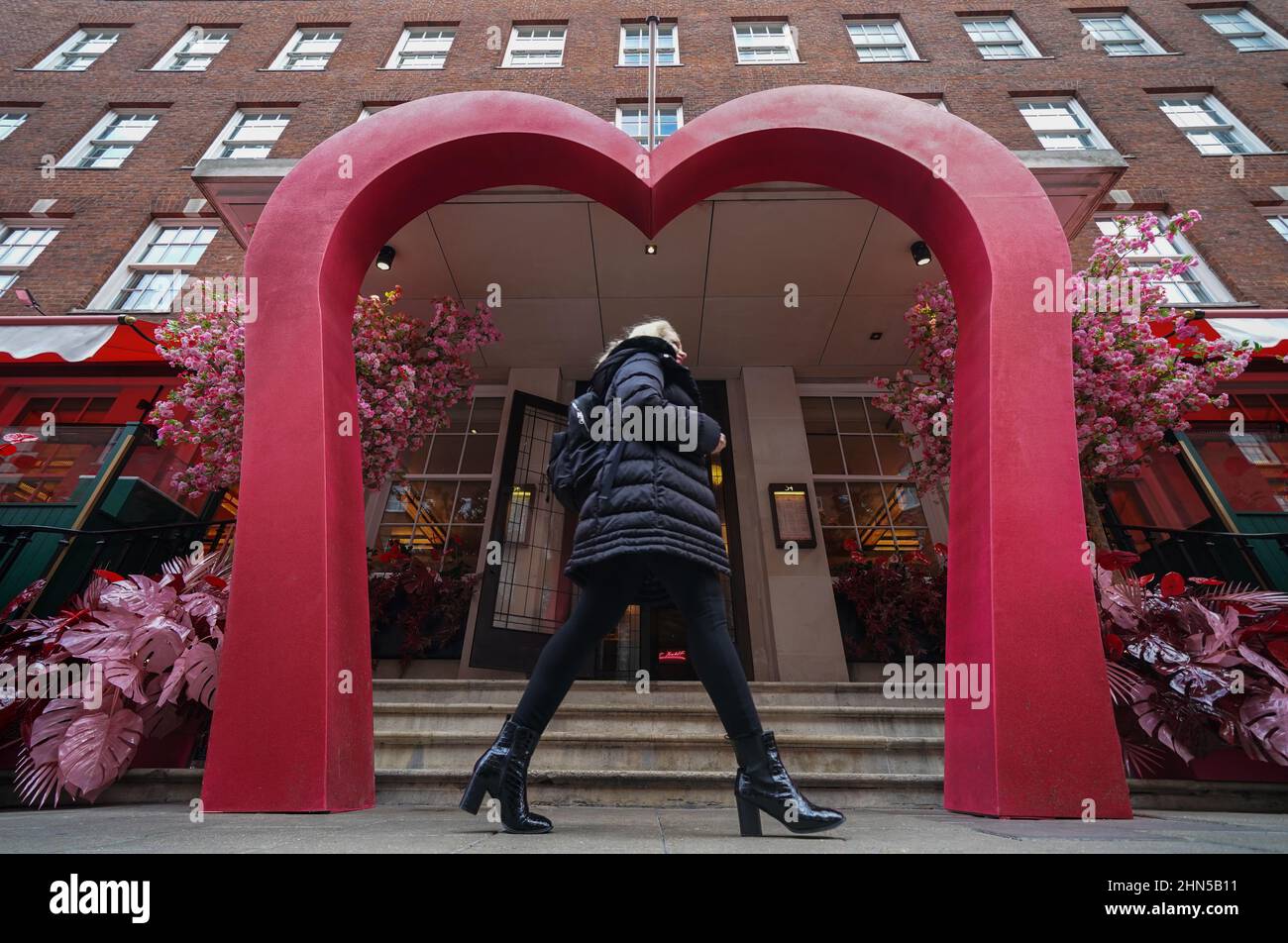A woman walks past decorations for Valentine's Day outside 34 Mayfair ...
