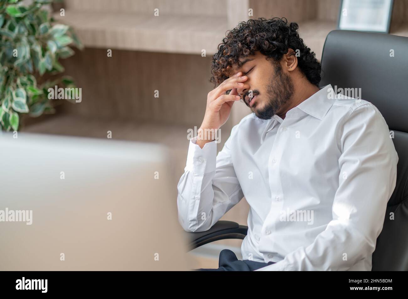 Young indian businessman looking tired Stock Photo - Alamy