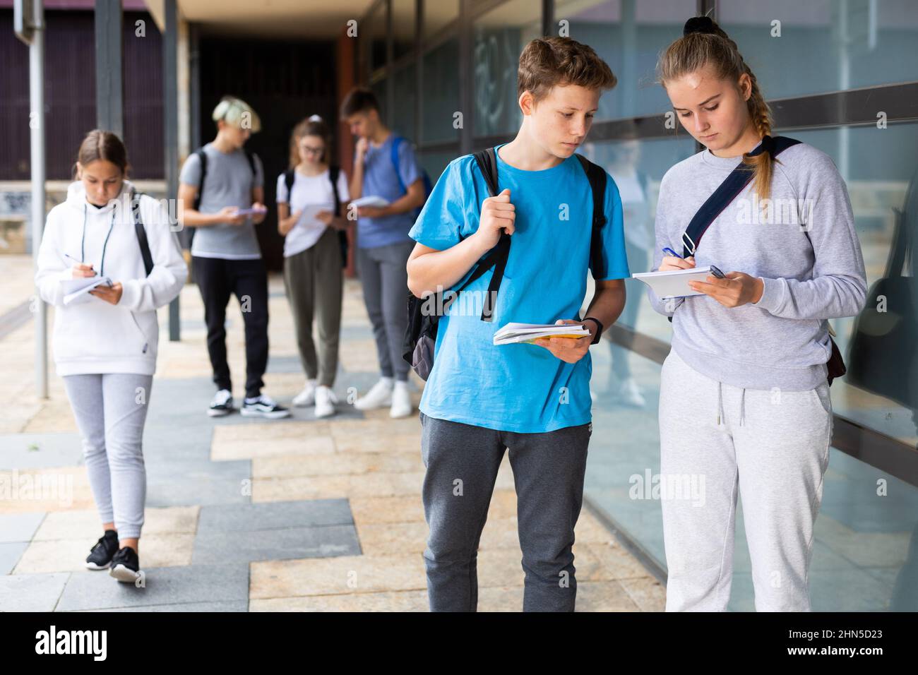 Teen boy talking to girl classmate in college campus Stock Photo - Alamy