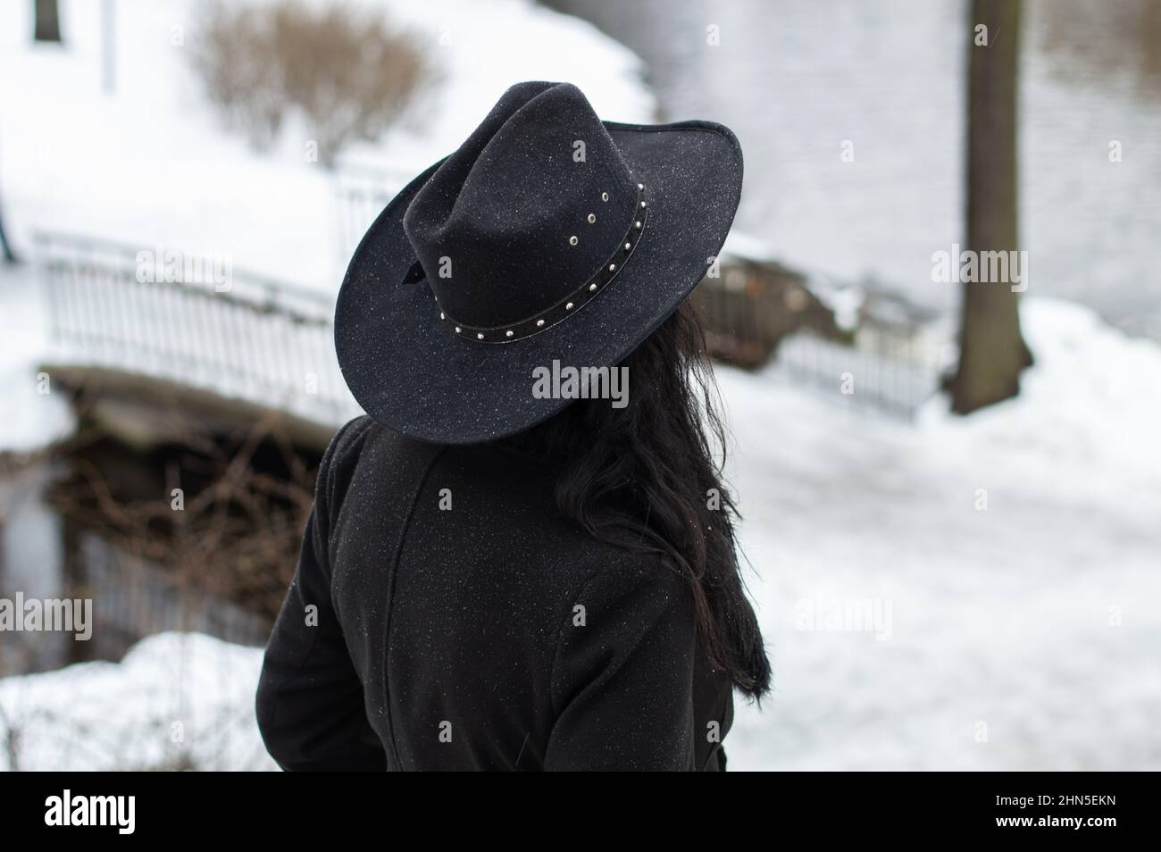 People from behind. woman in black clothing and cowboy hat from behind ...