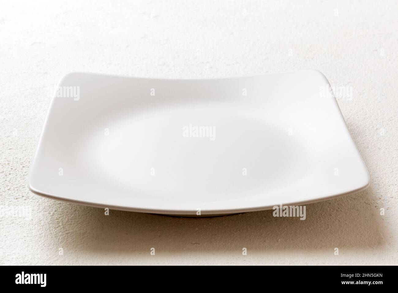 Perspective view of empty square plate on cement background. Empty ...