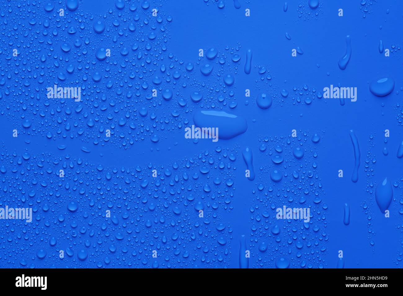 Water drops on blue color surface Stock Photo - Alamy