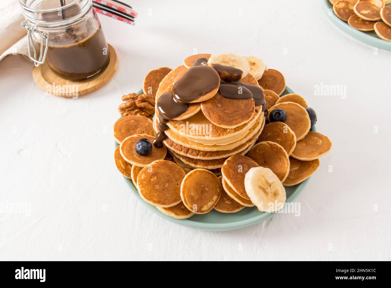fresh homemade mini pancakes on a ceramic plate with stackaya chocolate ...