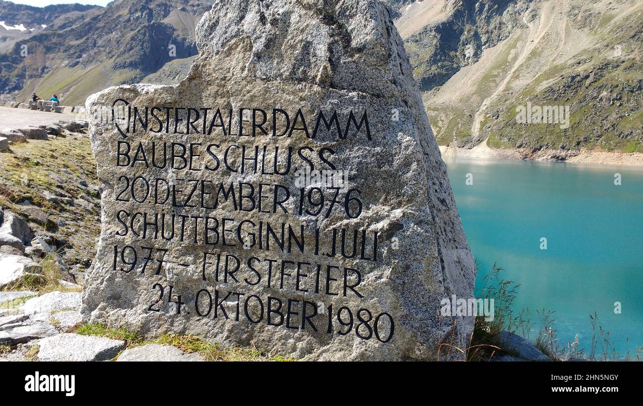 Monument stone in front of a reservoir Stock Photo - Alamy