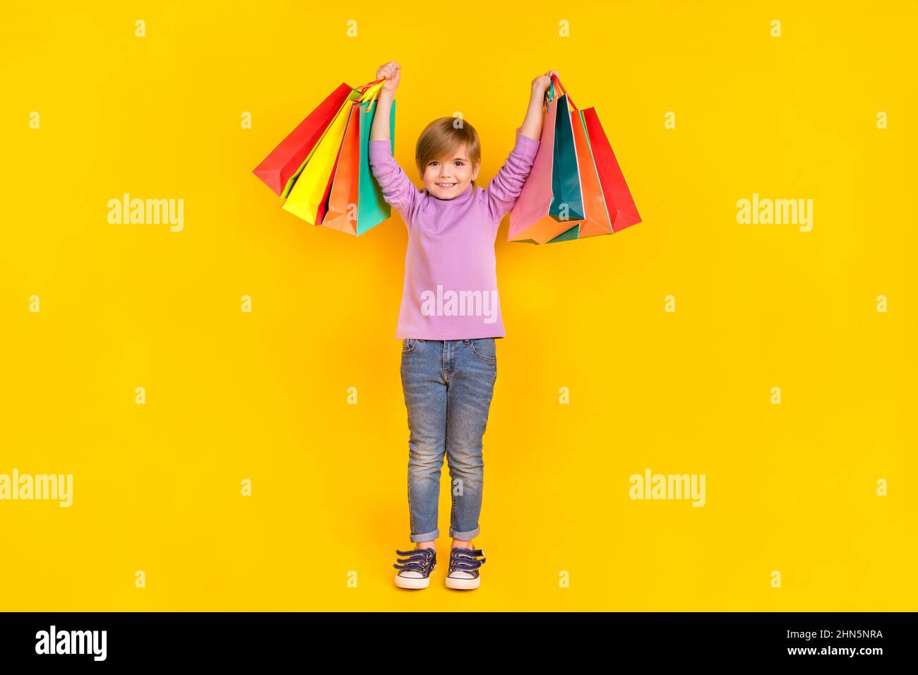 Full size photo of charming little boy go shopping show bags buy casual ...