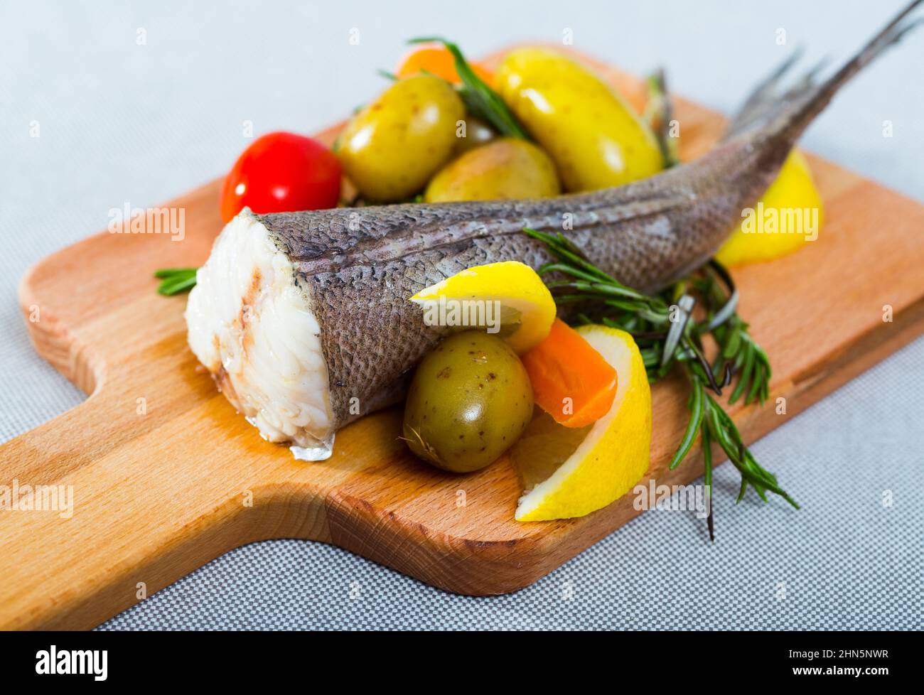 Country style baked merluccius Stock Photo - Alamy