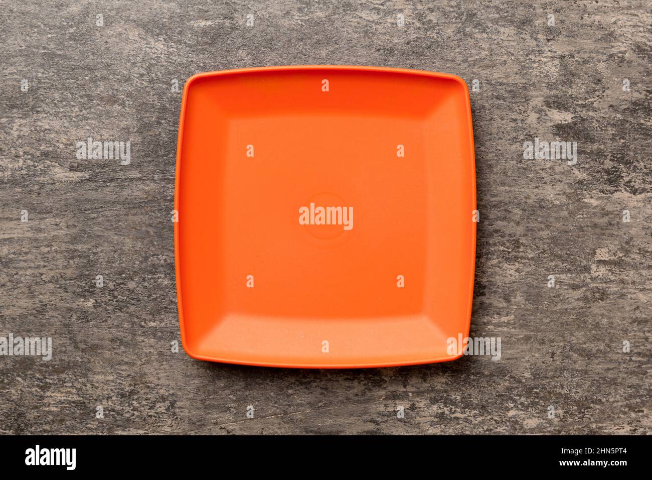 Top view of empty square plate on cement background. Empty space for ...