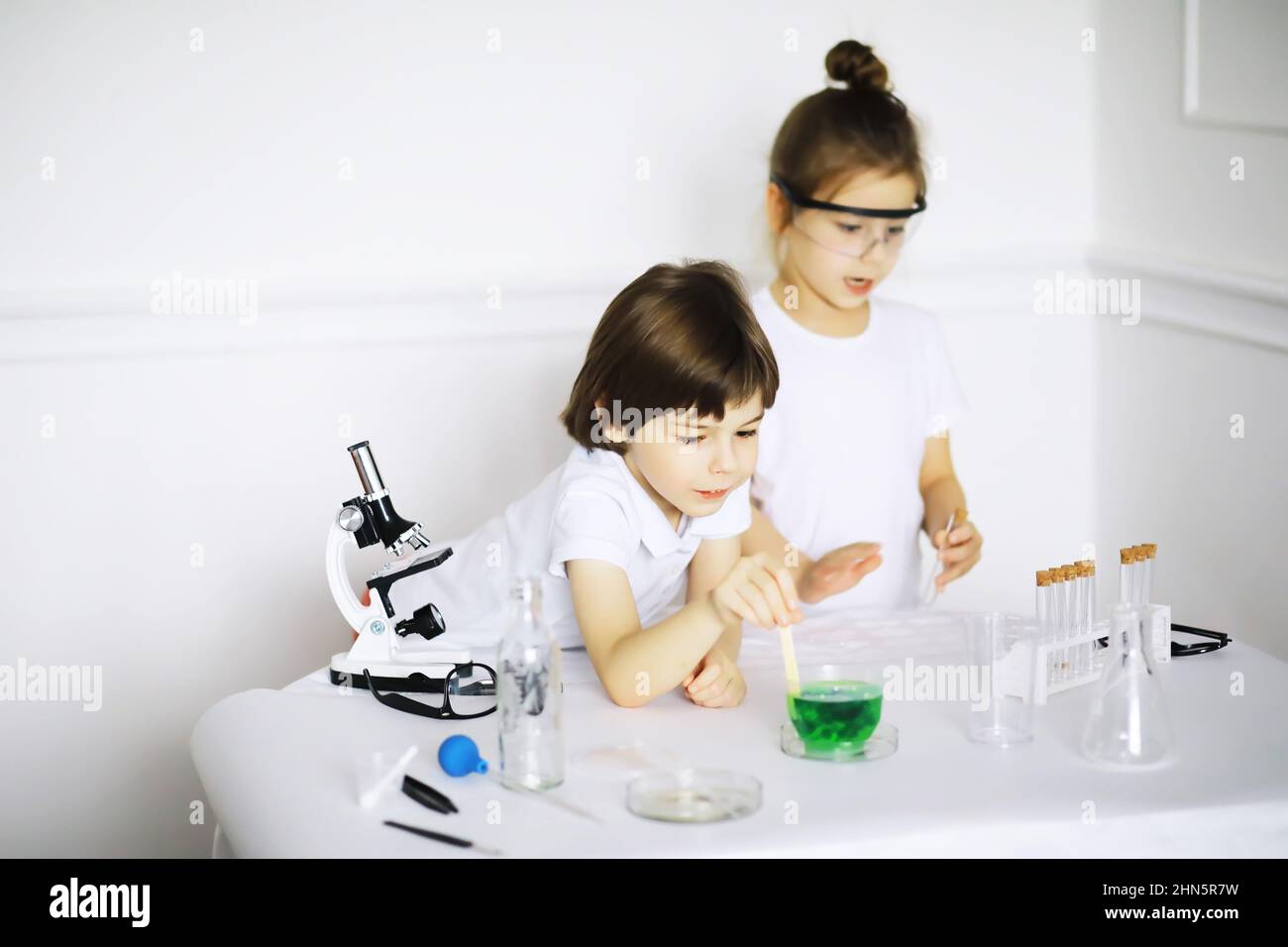 Two cute children at chemistry lesson making experiments isolated on ...