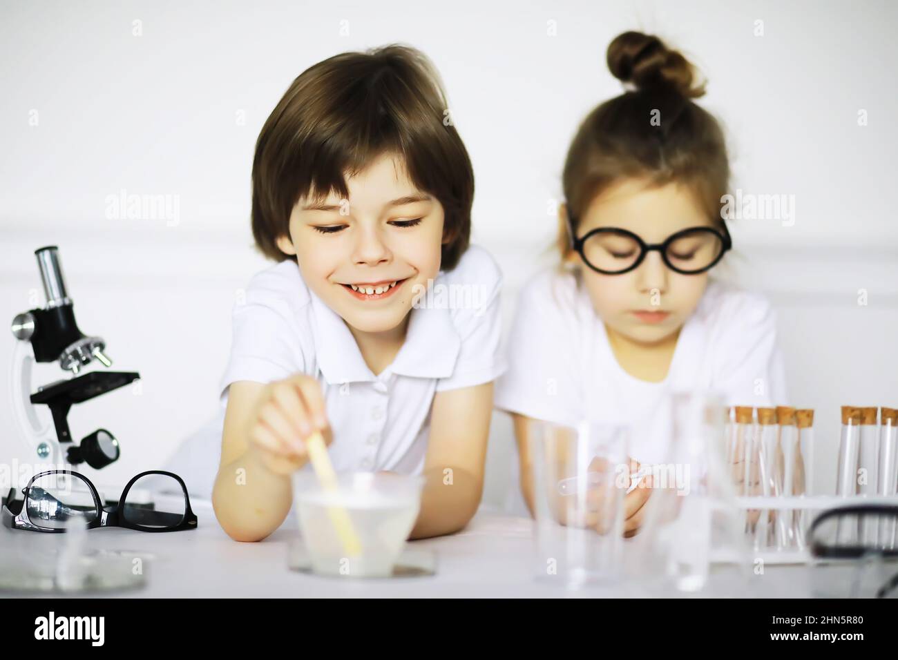 Two cute children at chemistry lesson making experiments isolated on ...