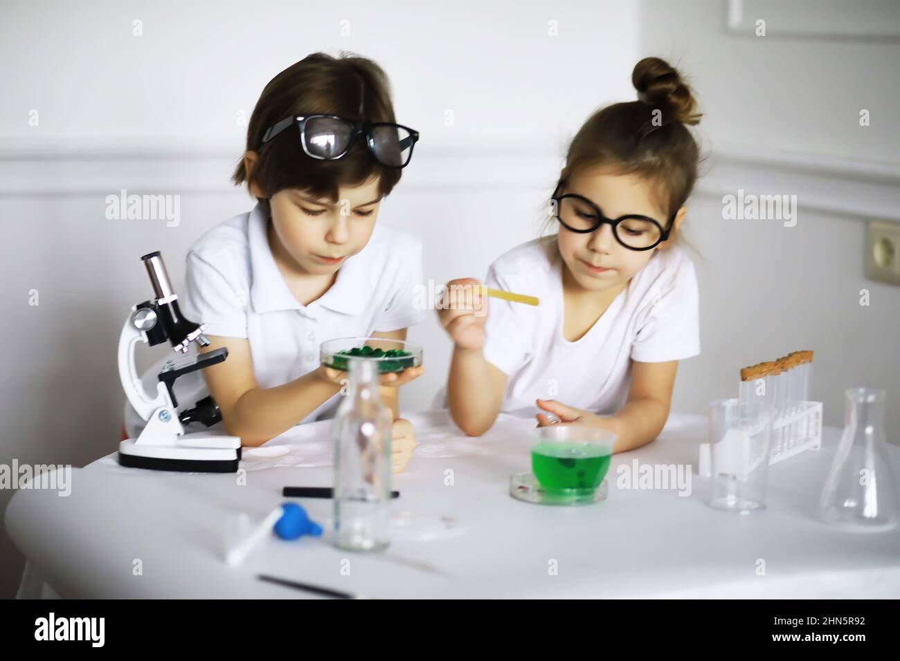 Two cute children at chemistry lesson making experiments isolated on ...