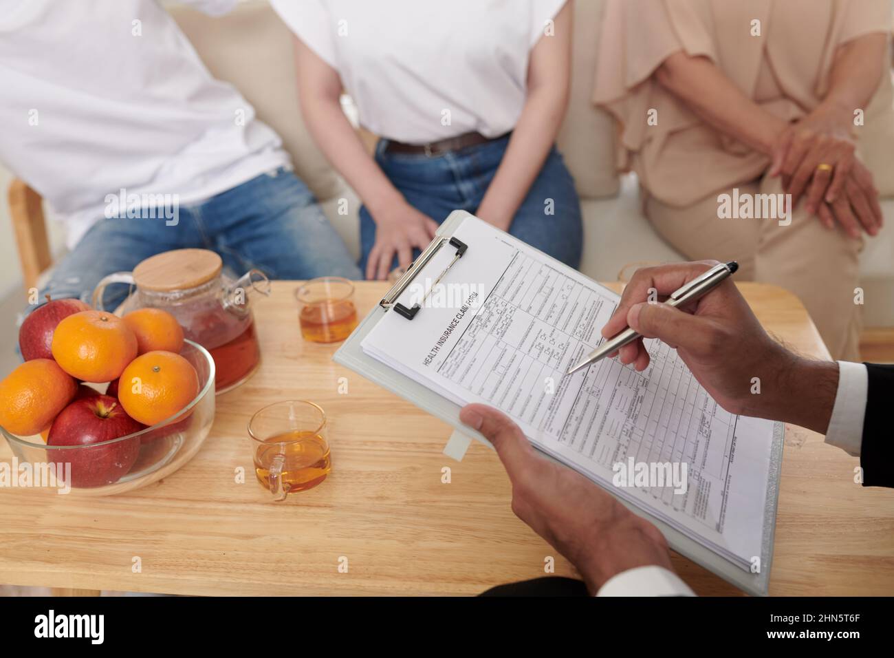 Insurance agent helping family to fill life insurance claim form for ...