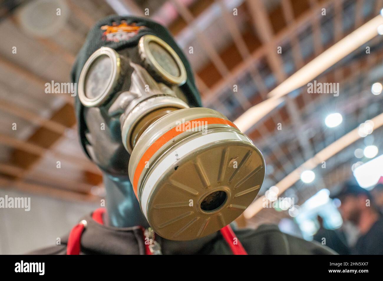 A black gas mask with a filter is worn on a mannequin. Bottom up view ...
