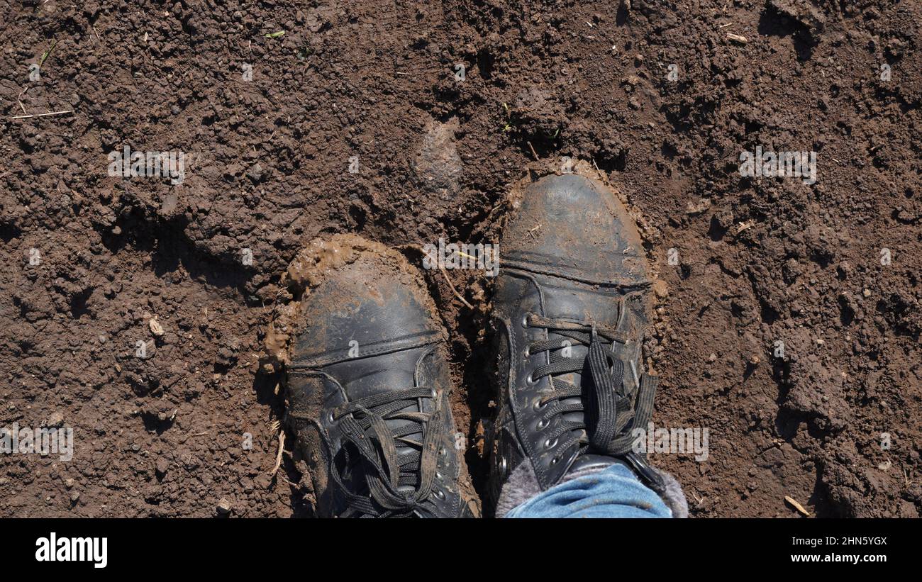 Women boots in the mud, detail of dirty boots and muddy, walk. Top down ...